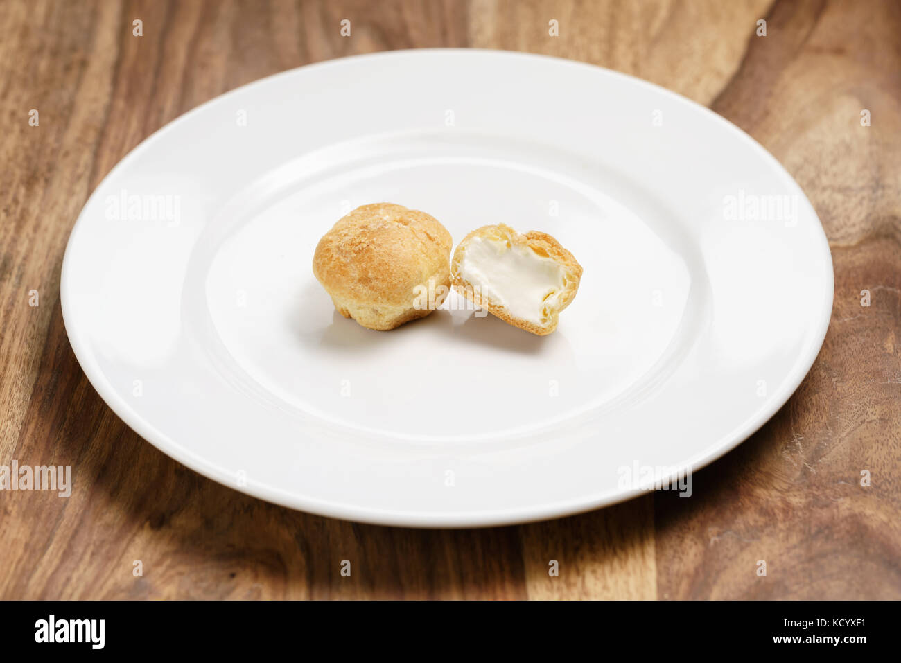 profiteroles on plate closeup one sliced Stock Photo - Alamy