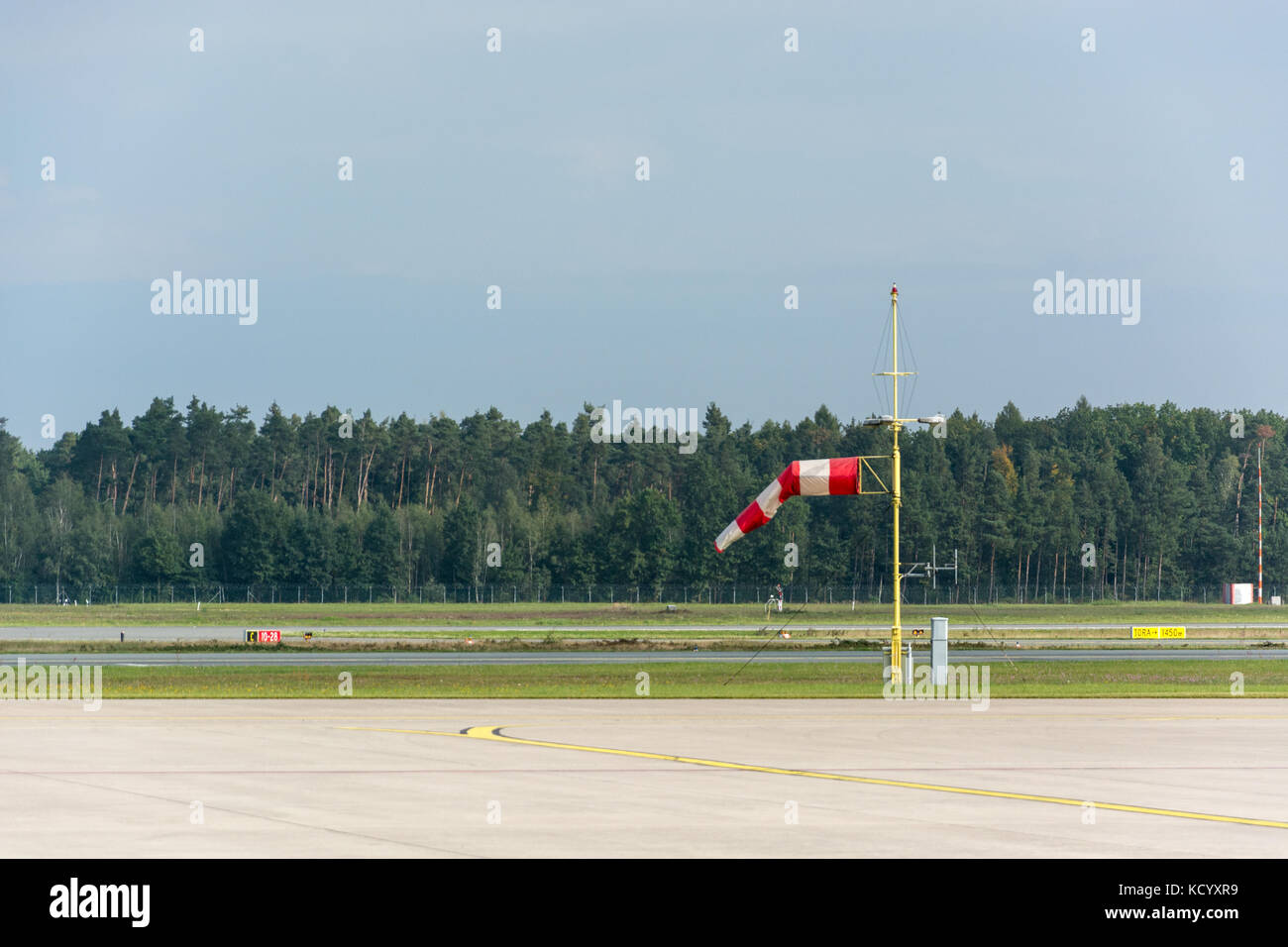 A red and white windsock at an airport runway Stock Photo - Alamy
