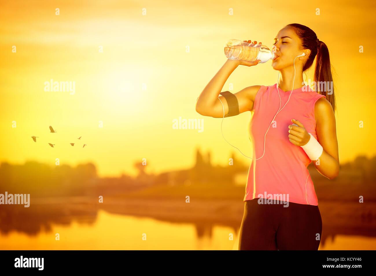 thirsty female jogger drinking water from bottle Stock Photo - Alamy