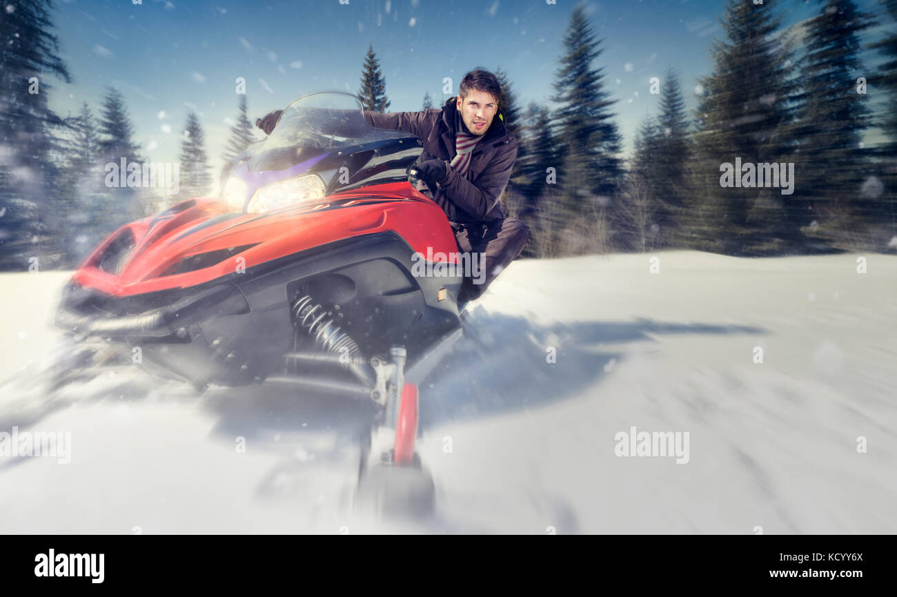 young man driving snowmobile at beautiful winter day - in motion Stock ...