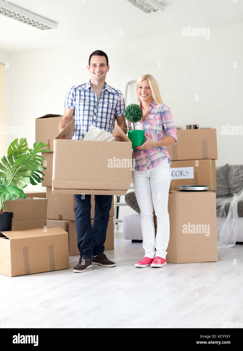 Couple moving home with lot of boxes around them Stock Photo - Alamy