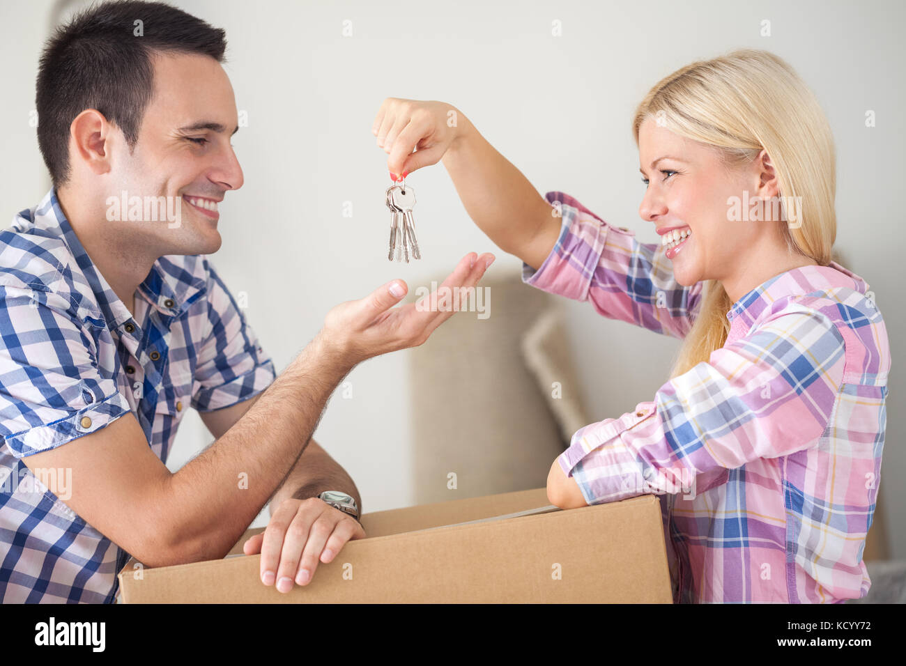 Moving into new home young happy couple, girl holding house keys and ...