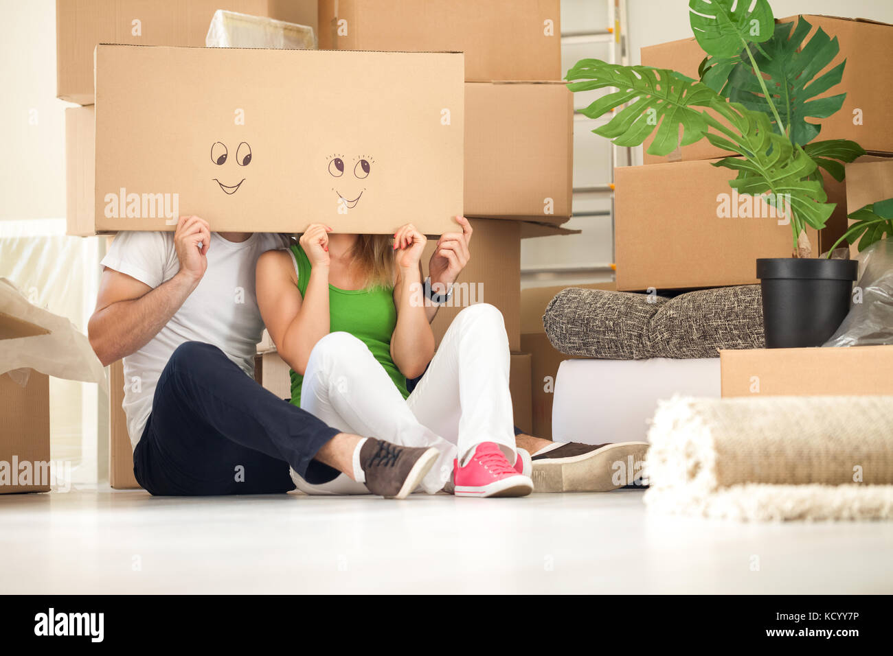 Couple with empty boxes on heads with smiley on it Stock Photo - Alamy