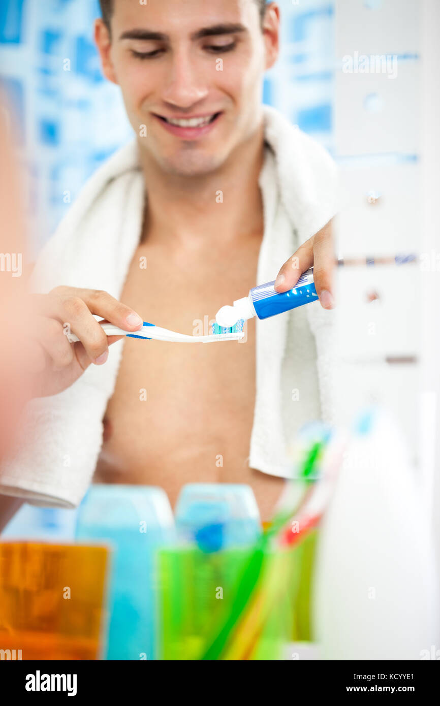 Young man holding toothbrush and toothpaste, routine Stock Photo - Alamy