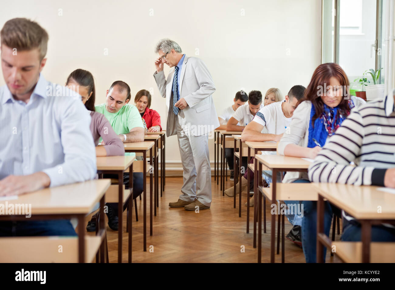 Senior teacher with class in a classroom Stock Photo - Alamy