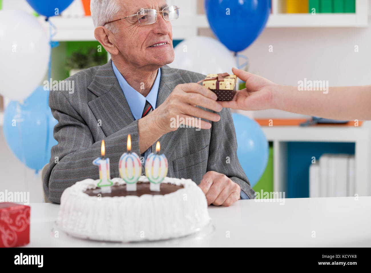 Smiling senior man receiving birthday gift, celebrating 100th birthday ...