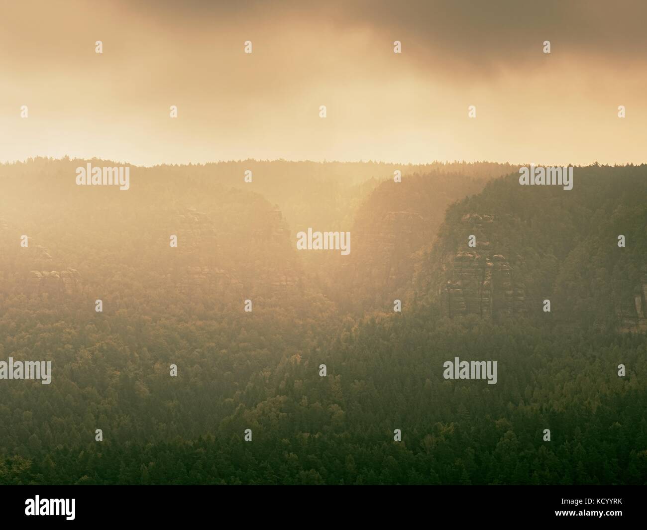 Cold and damp morning in autumn nature. Outlines of forest hills hidden ...