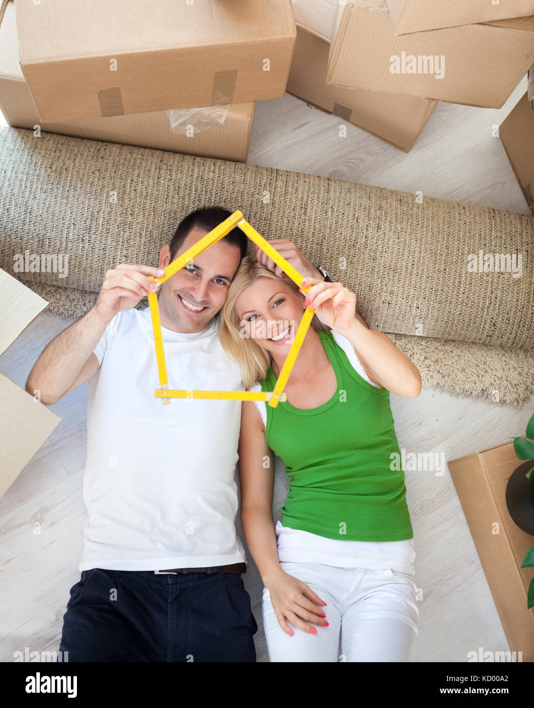 Couple lying on floor and looking through a house-frame, enjoying in ...