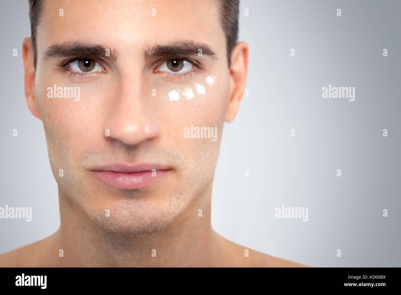 Face of handsome young man with moisturizer applied under his eyes Stock Photo - Alamy