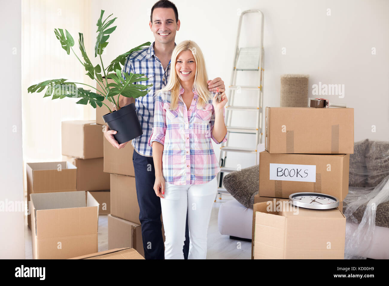 Young couple standing in new home Stock Photo - Alamy
