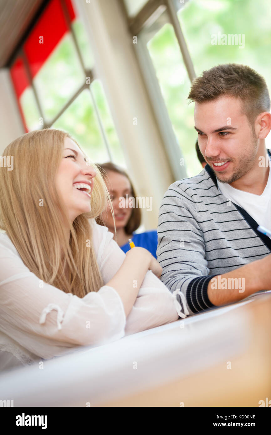 Happy young students talking in classroom Stock Photo - Alamy