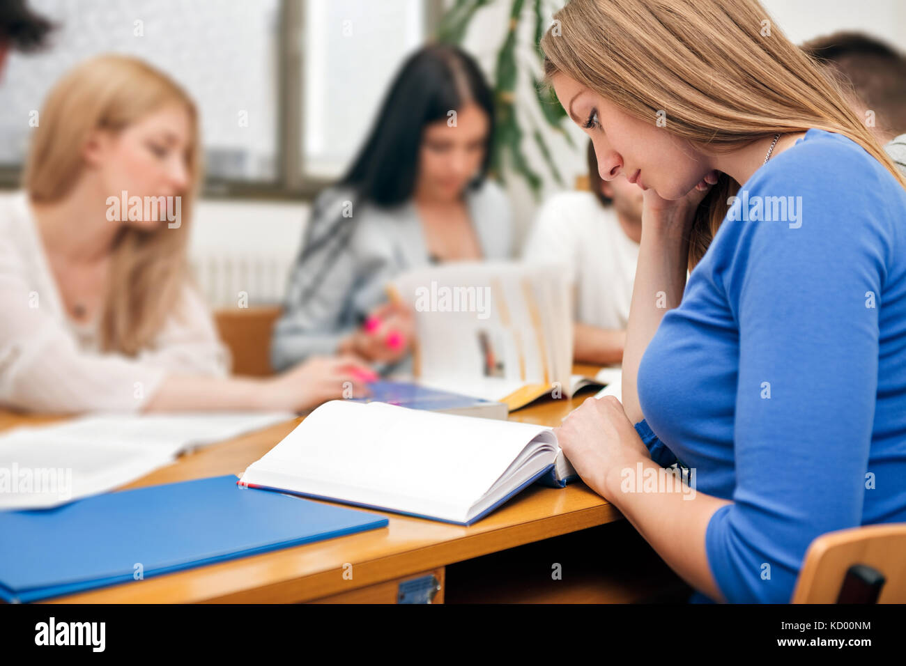 Students sitting at desk with books and learning Stock Photo - Alamy