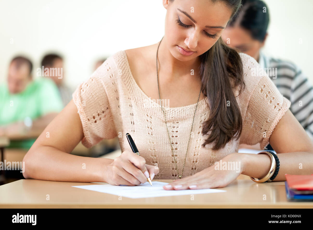 Student girl sitting for exam in a classroom Stock Photo - Alamy