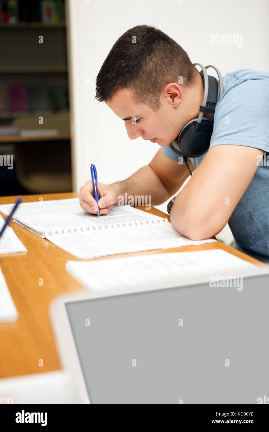 male high school student in classroom, he focused on writing Stock ...