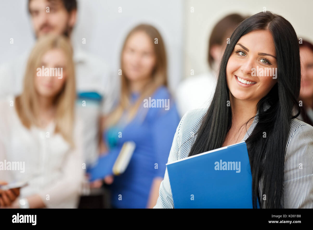 Portrait of smiling beautiful student with books in classroom Stock ...