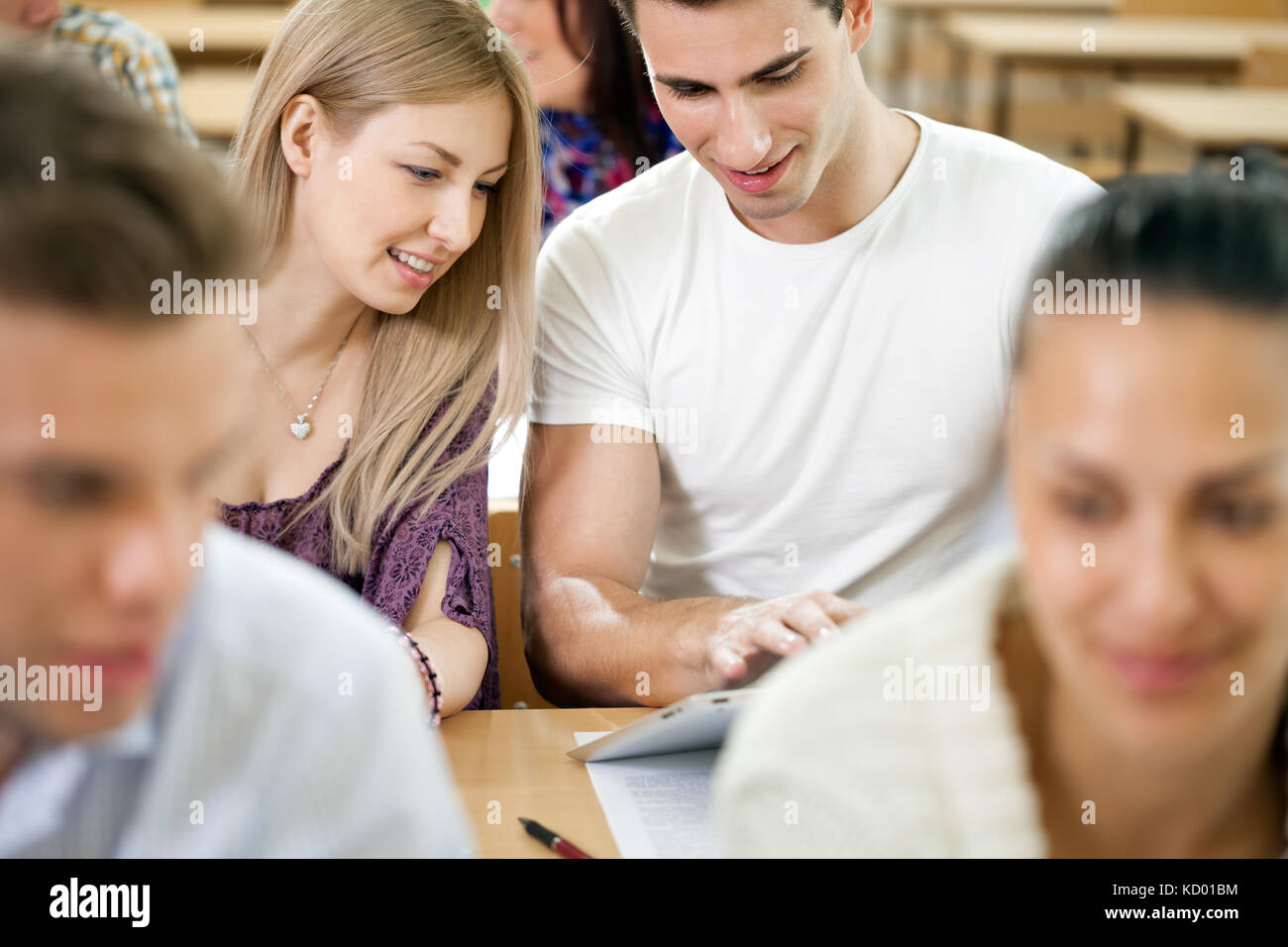Couple students in classroom full of students Stock Photo - Alamy