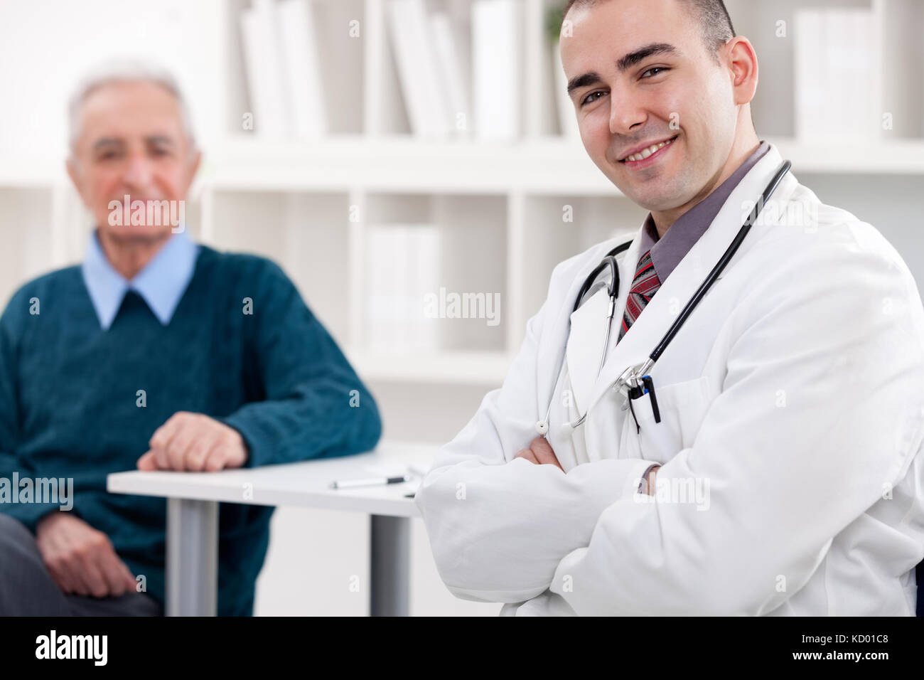 Success young doctor with patient in background Stock Photo - Alamy