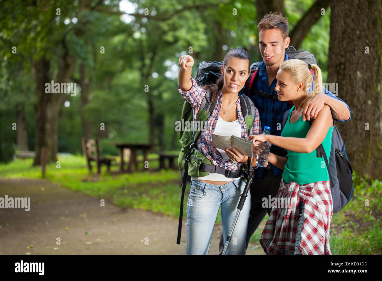 Group hikers with backpacks reading at map Stock Photo - Alamy