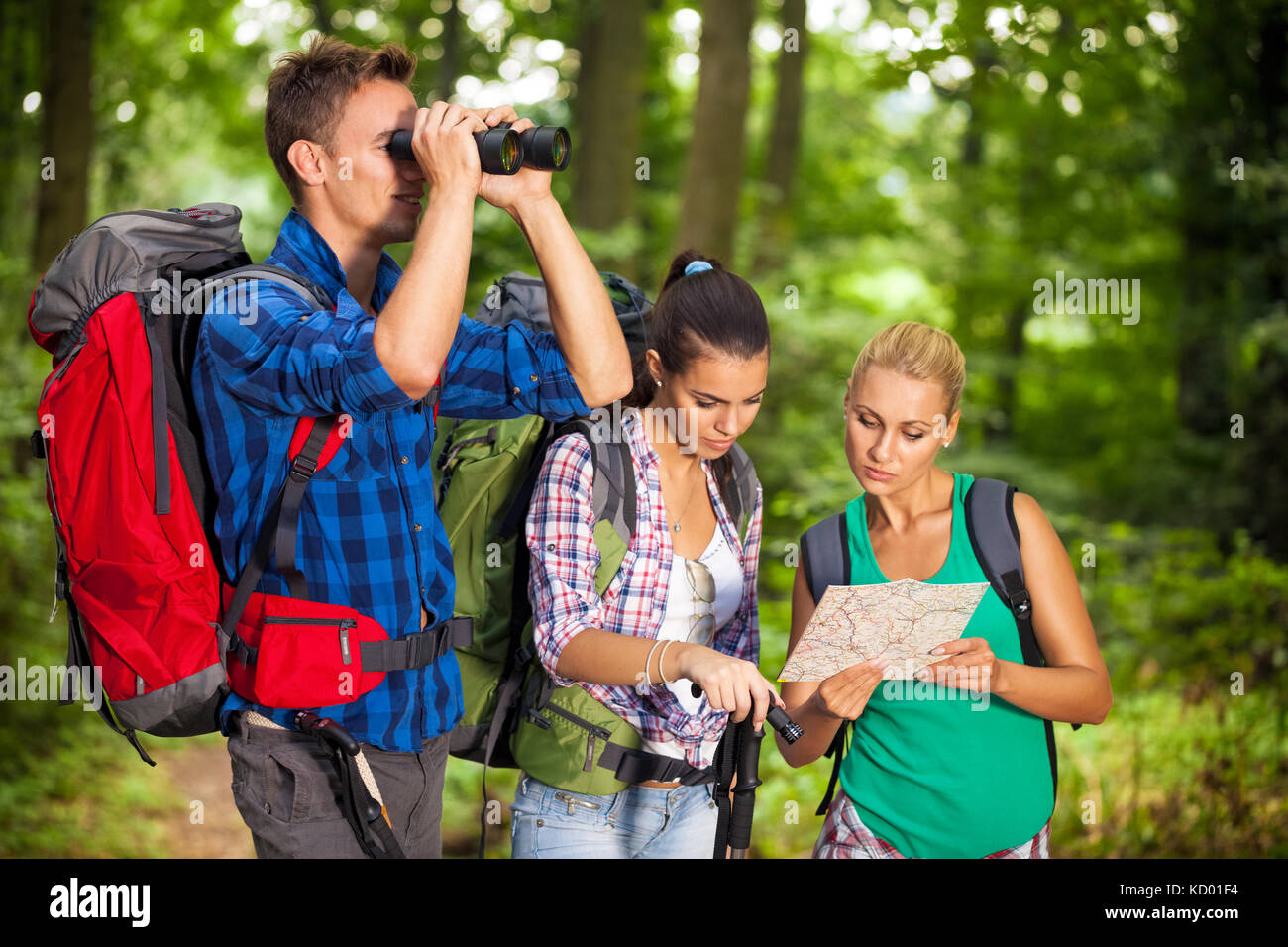Hikers group man looking through binoculars and girls reading map Stock ...