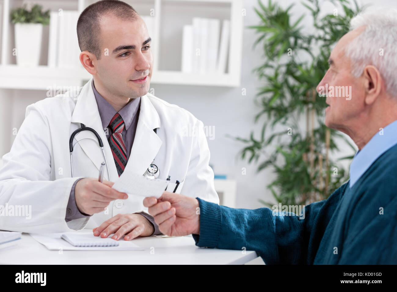 Male doctor giving a prescription at patient Stock Photo - Alamy