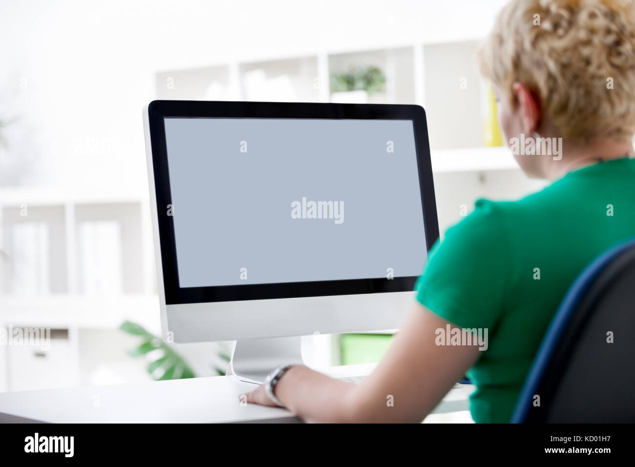 Rear view closeup of a young woman working of a computer Stock Photo ...