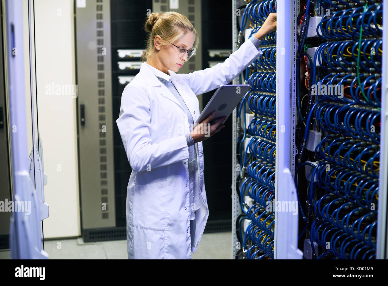 Side view portrait of young woman wearing lab coat working with ...