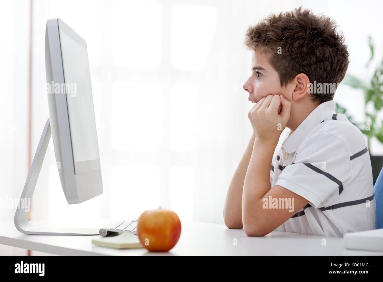 Very focused boy looking interesting move on computer screen Stock ...