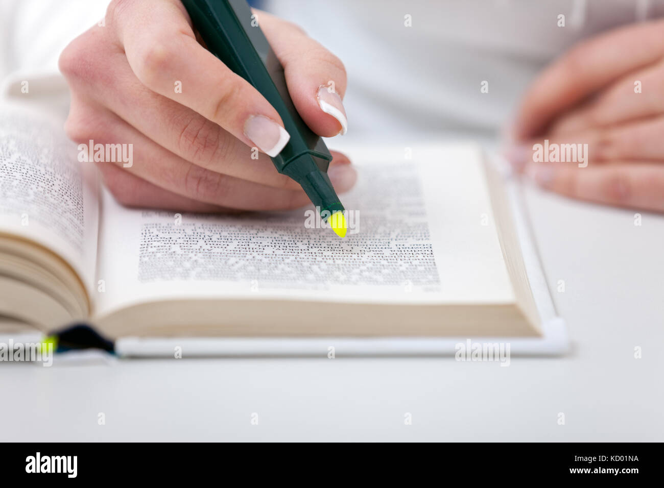 Highlighter in female hand marked text in book, education concept Stock ...