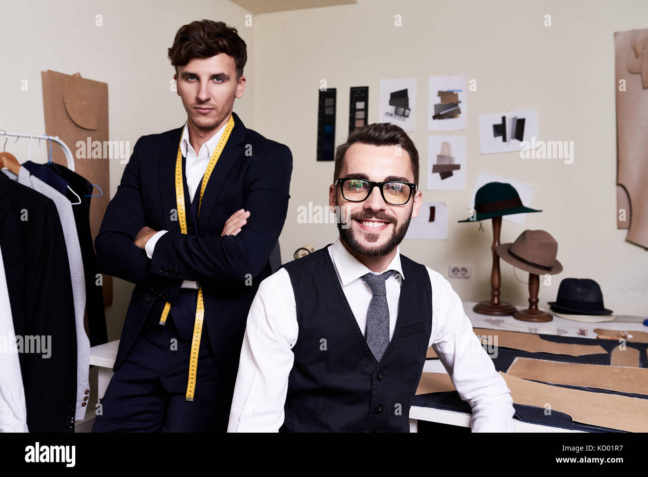 Portrait of two handsome young tailors posing, looking at camera in ...
