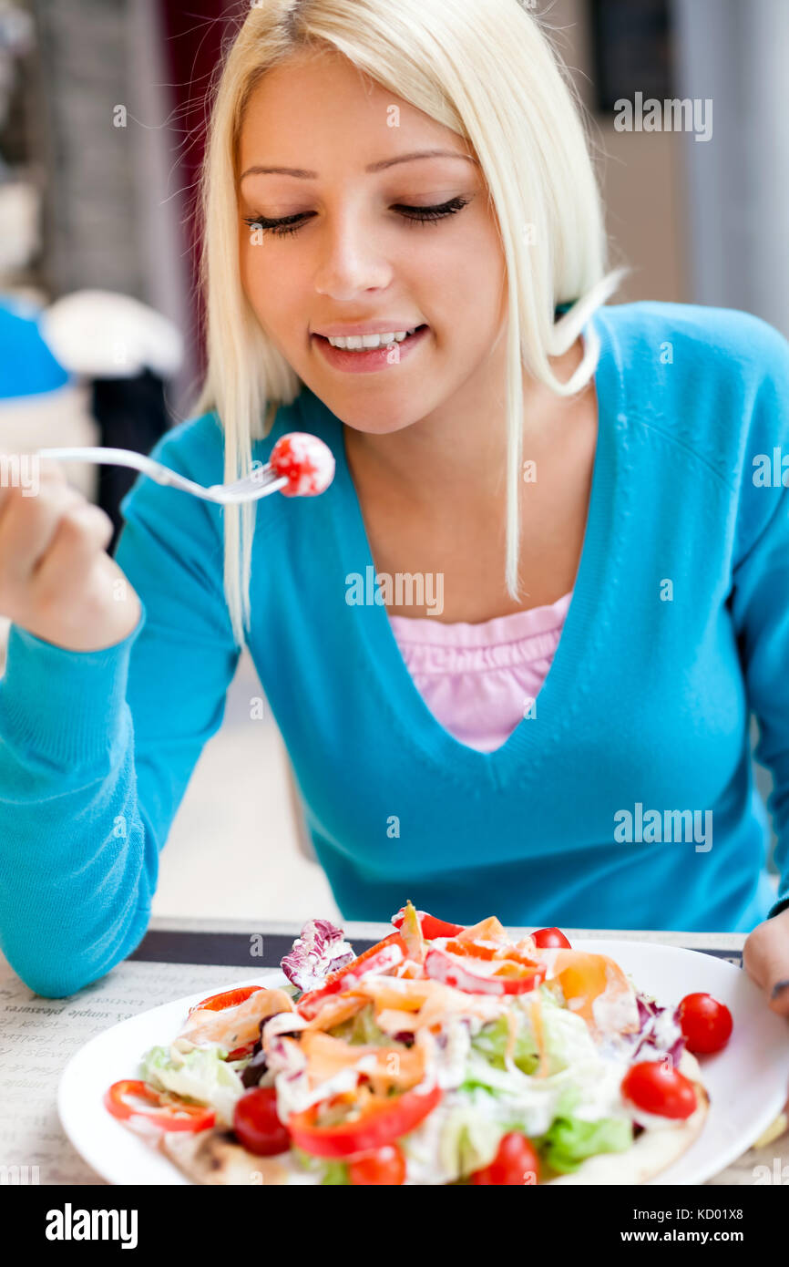 Beautiful hungry girl having lunch at restaurant Stock Photo - Alamy