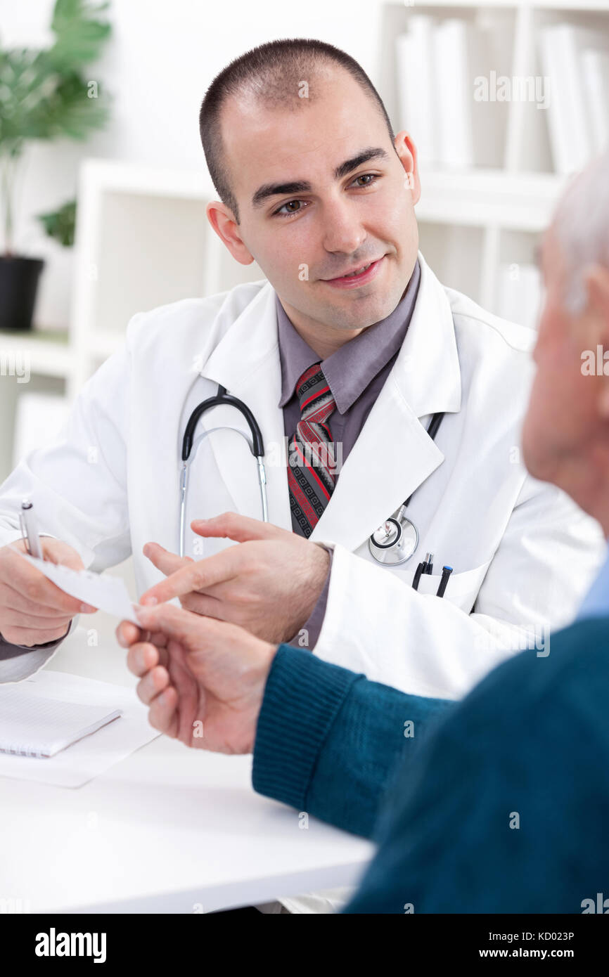Handsome male doctor giving a prescription to his patient Stock Photo ...