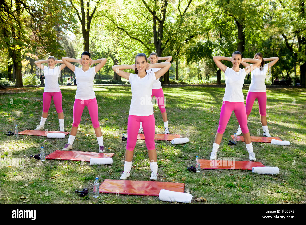 Group of women doing warm up exercises at the park Stock Photo - Alamy