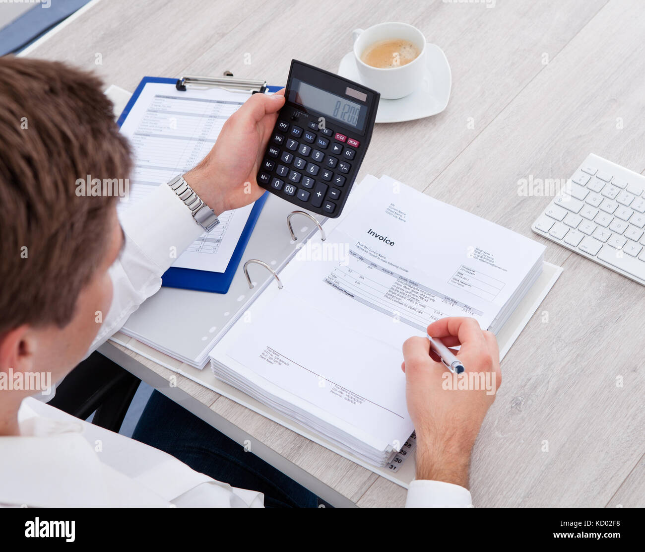 Happy Young Businessman Calculating Bills At Desk Stock Photo - Alamy