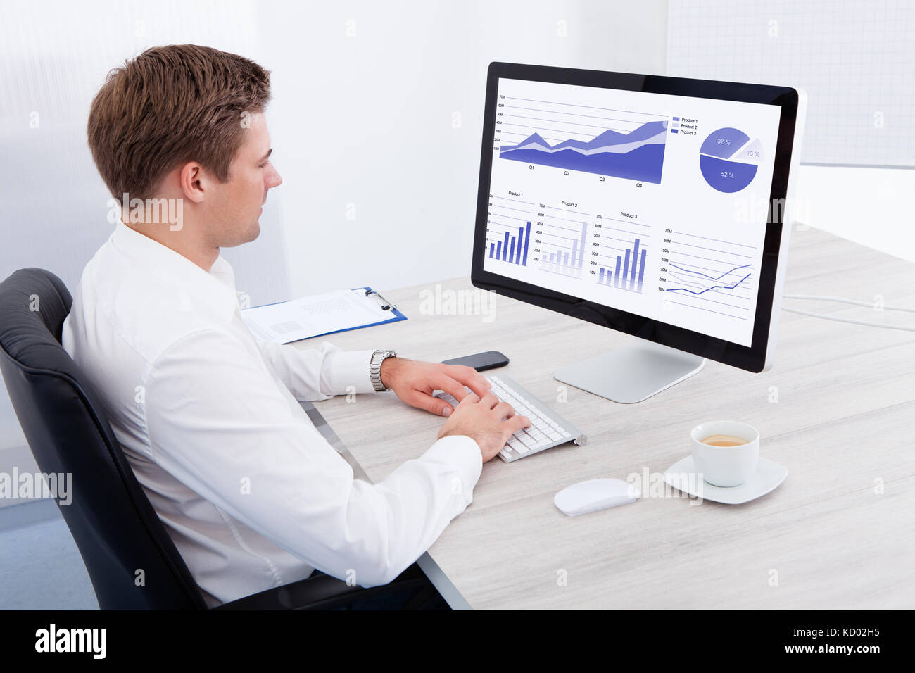 Portrait Of Young Businessman Using Computer At Desk Stock Photo - Alamy