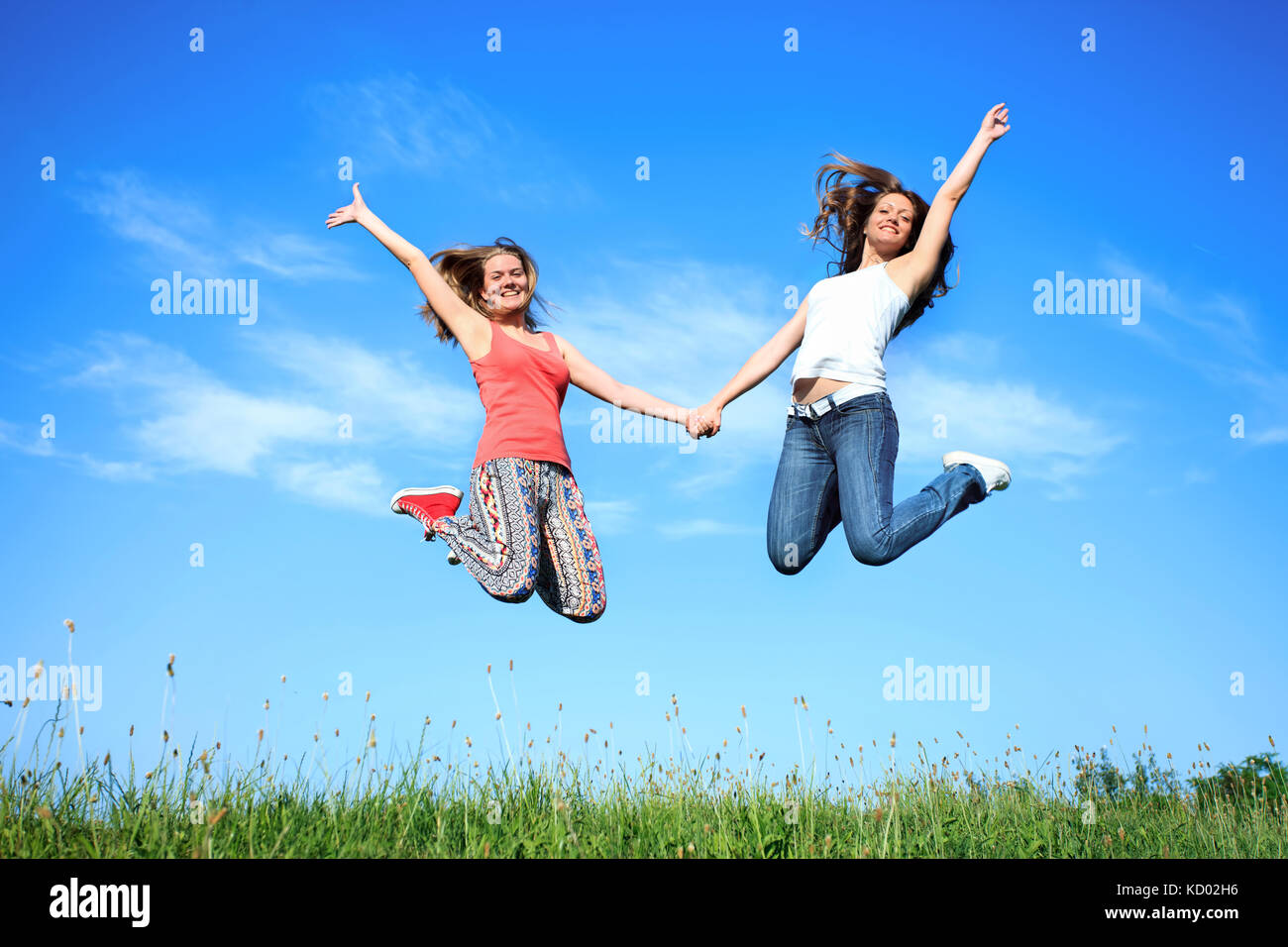 Fun young girls jumping, outdoors Stock Photo - Alamy