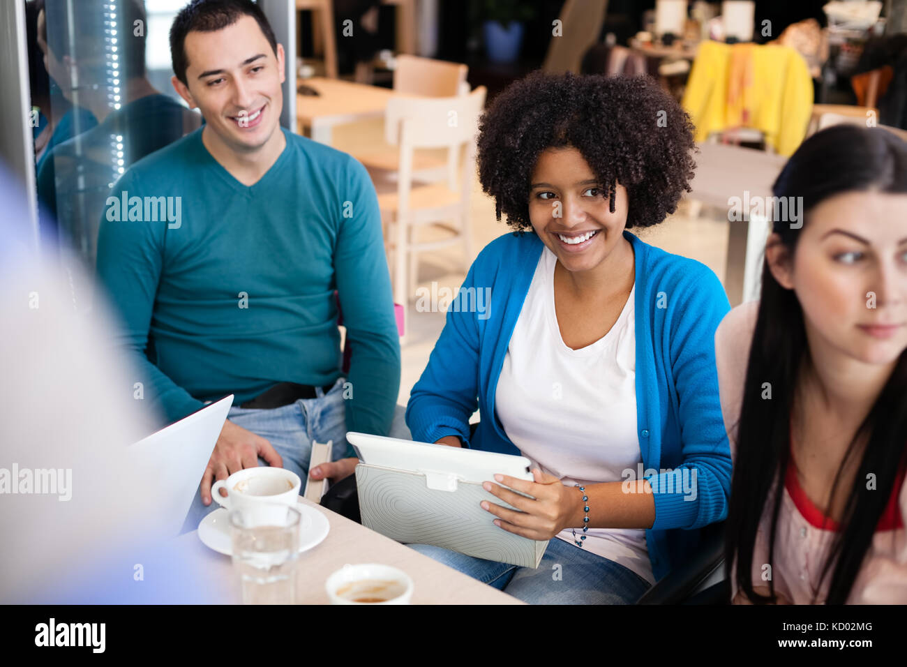 Happy students in café with tablet Stock Photo - Alamy