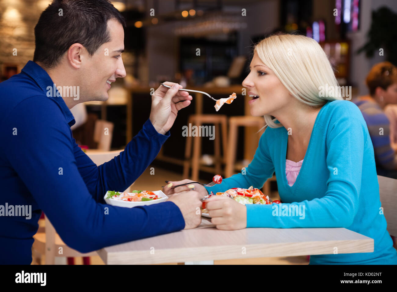 young men feeding his girlfriend, romantic lunch Stock Photo - Alamy