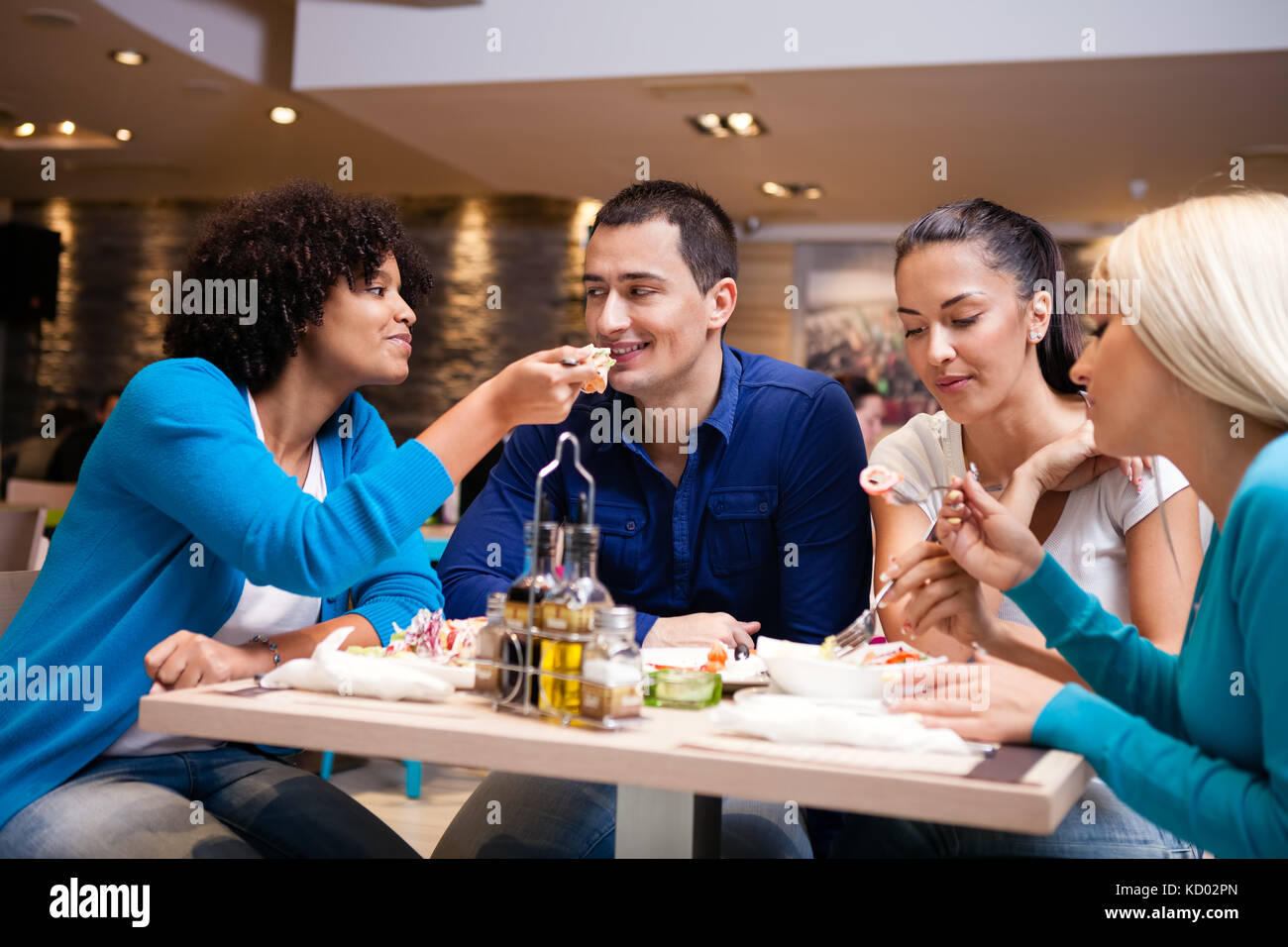 Four young friends eating in a restaurant or diner Stock Photo - Alamy