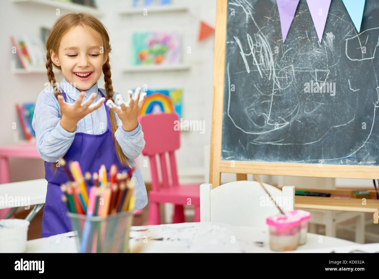 Portrait of cute little girl enjoying art and craft lesson in ...