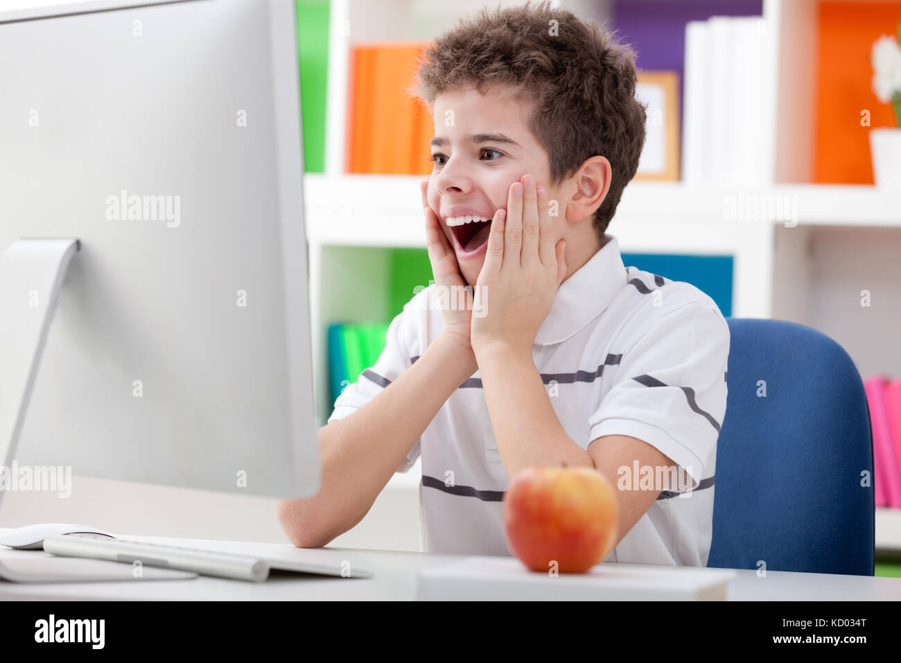 Surprised boy with computer with expressing face Stock Photo - Alamy