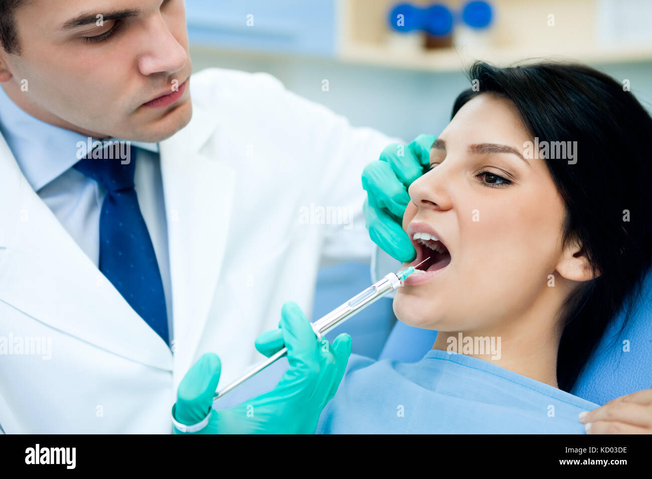 Dentist giving injection for anesthetizing his patient Stock Photo - Alamy
