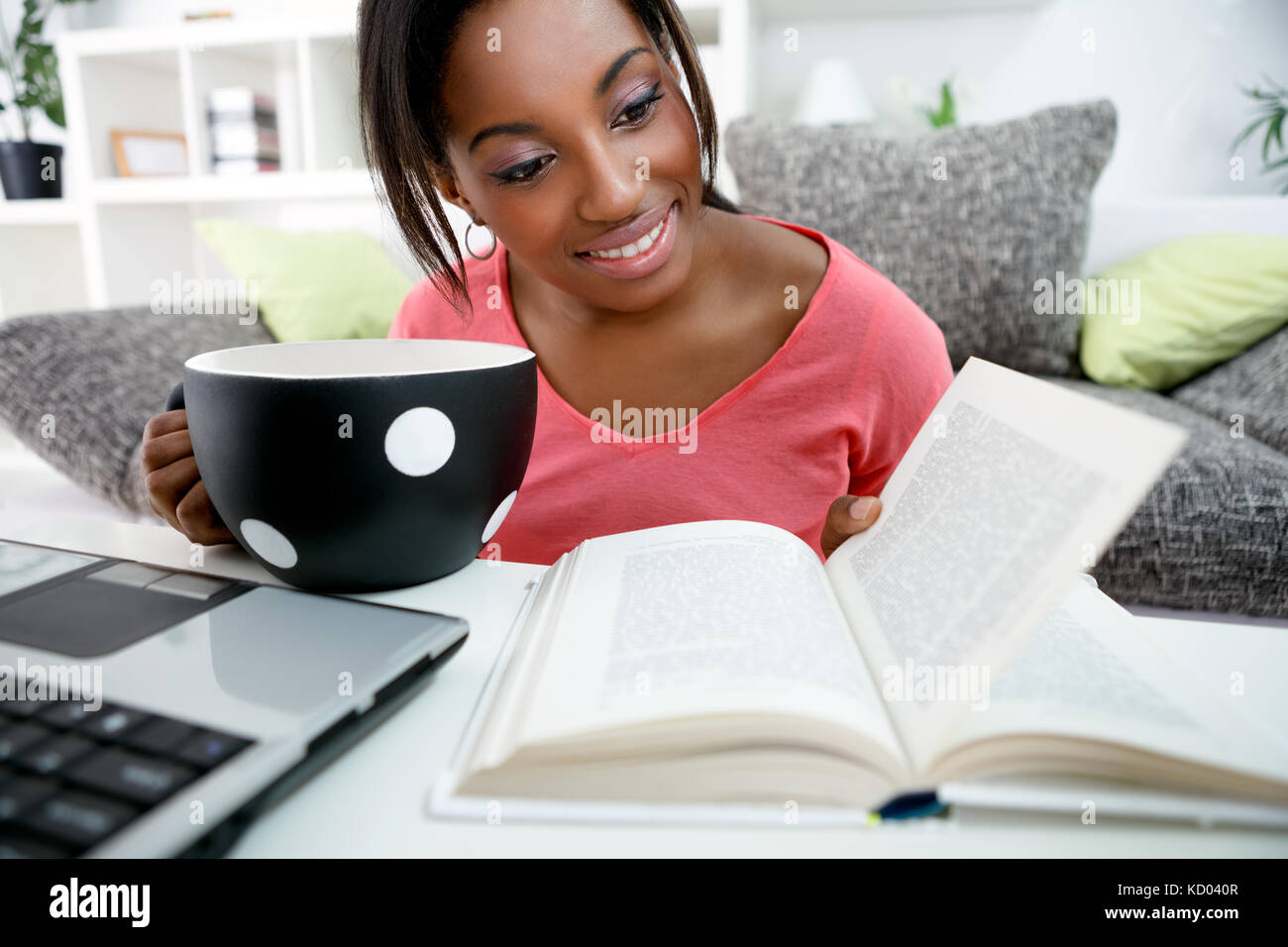Young African student with books and laptop learning at home Stock ...