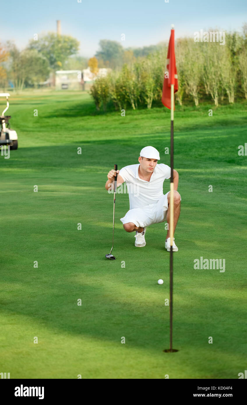 Young golfer lining up a putt Stock Photo - Alamy