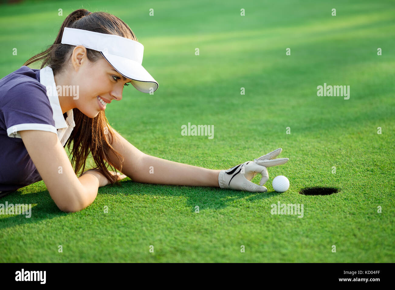 female golfer flick the golf ball into the hole Stock Photo - Alamy