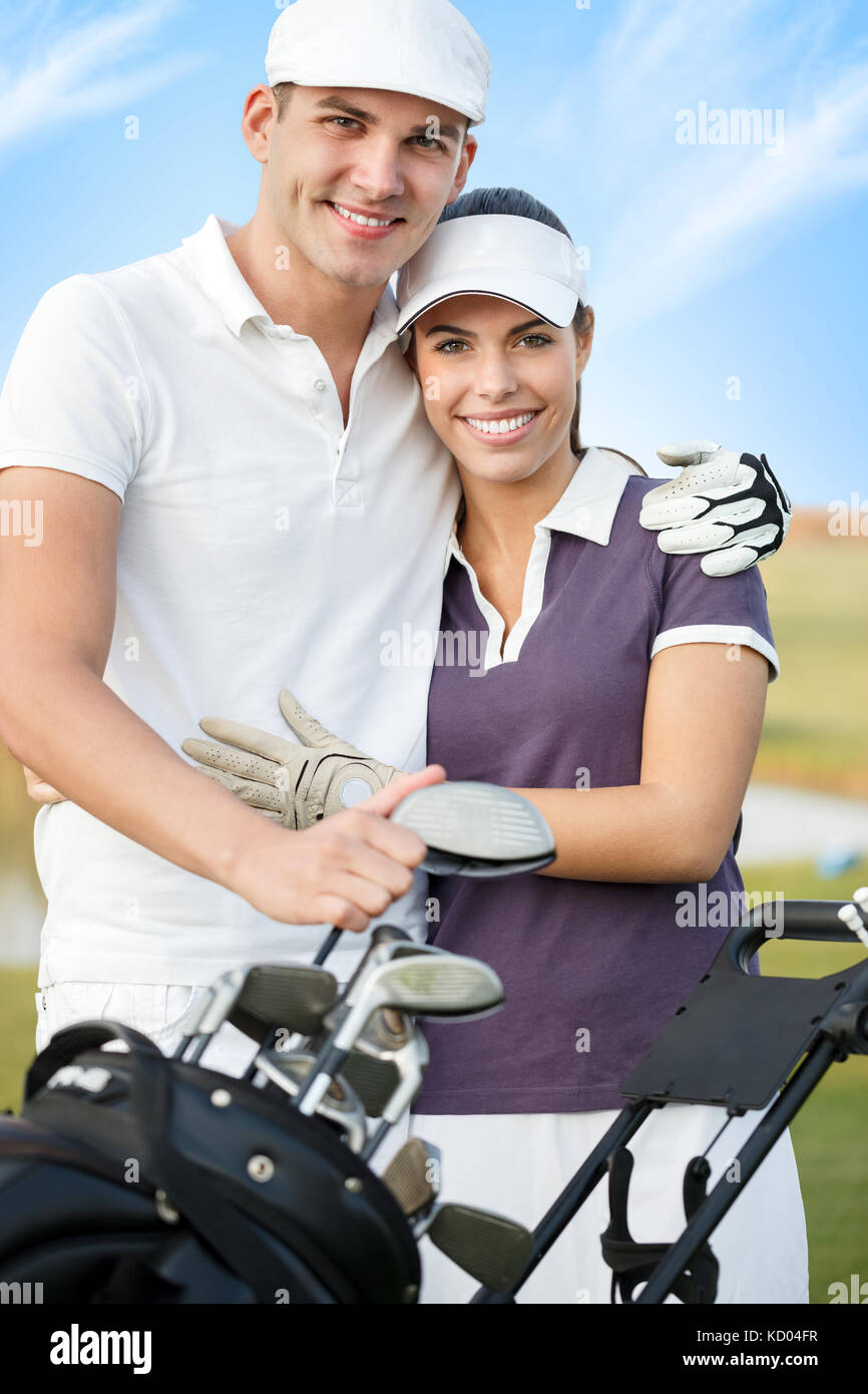 cheerful couple on golf course, hugging and looking at camera Stock ...