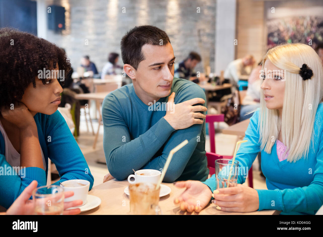 Three young friends enjoy in coffee in a cafe Stock Photo - Alamy