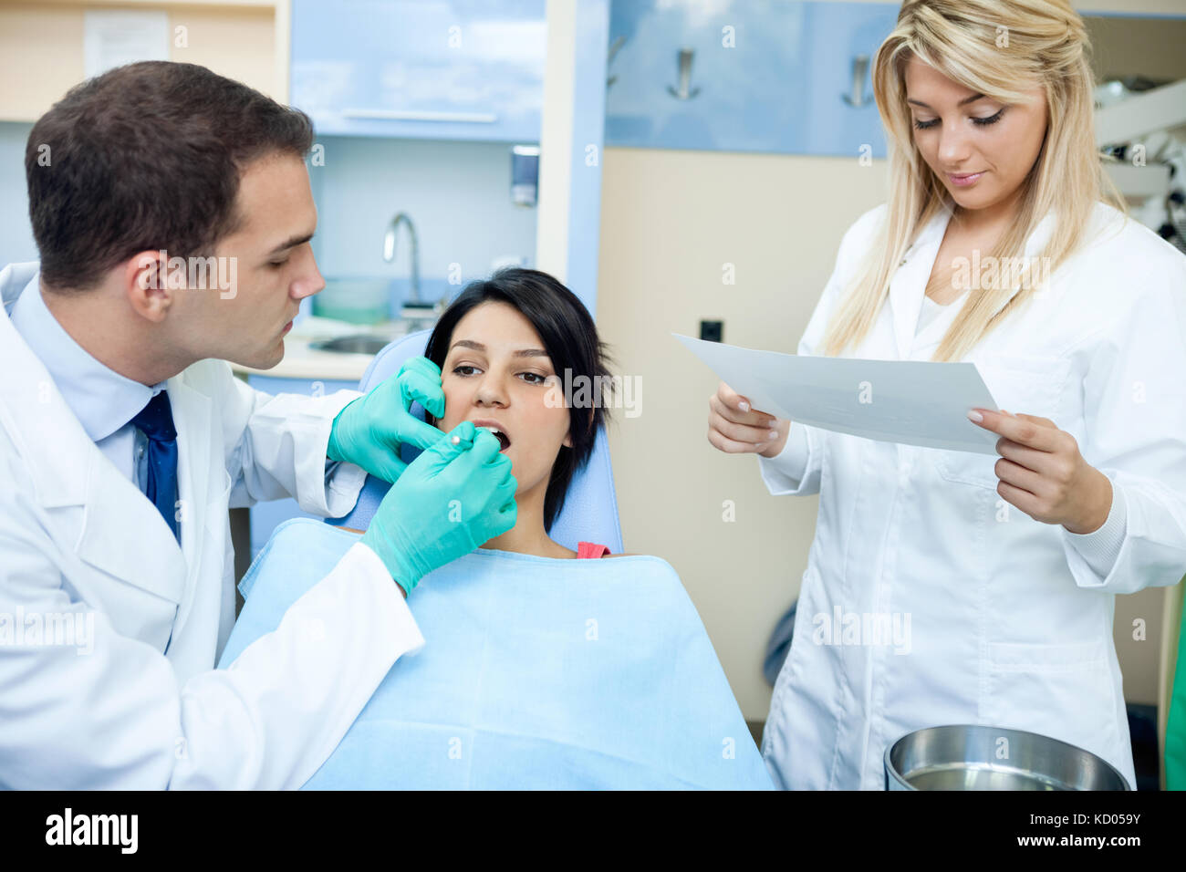 dentist and a nurse curing teeth of female patient Stock Photo - Alamy