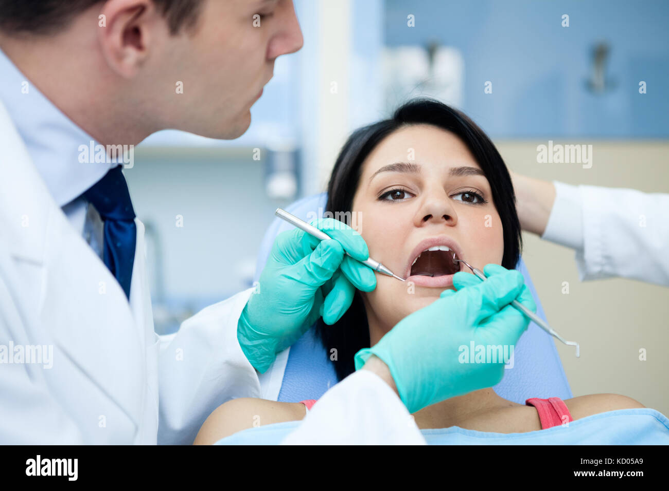 Close-up of patient before oral inspection with hook and mirror near by ...