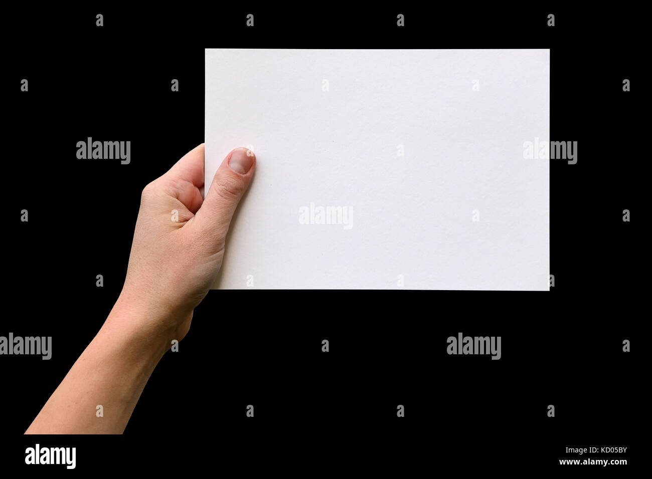 Female hand holding paper blank isolated on black Stock Photo - Alamy