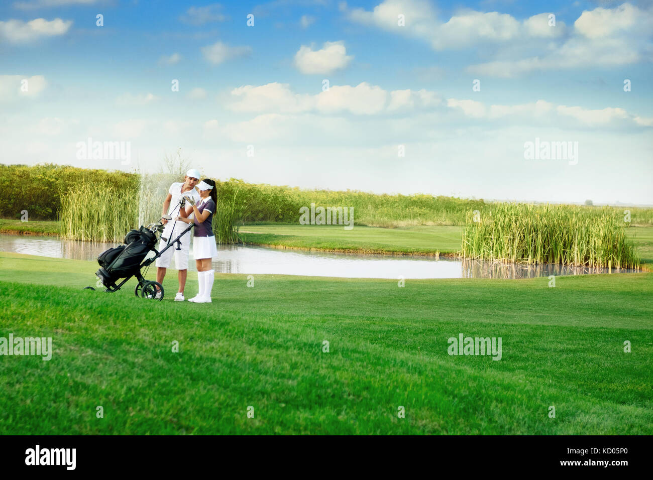 Young sporty couple playing golf on a golf course Stock Photo - Alamy